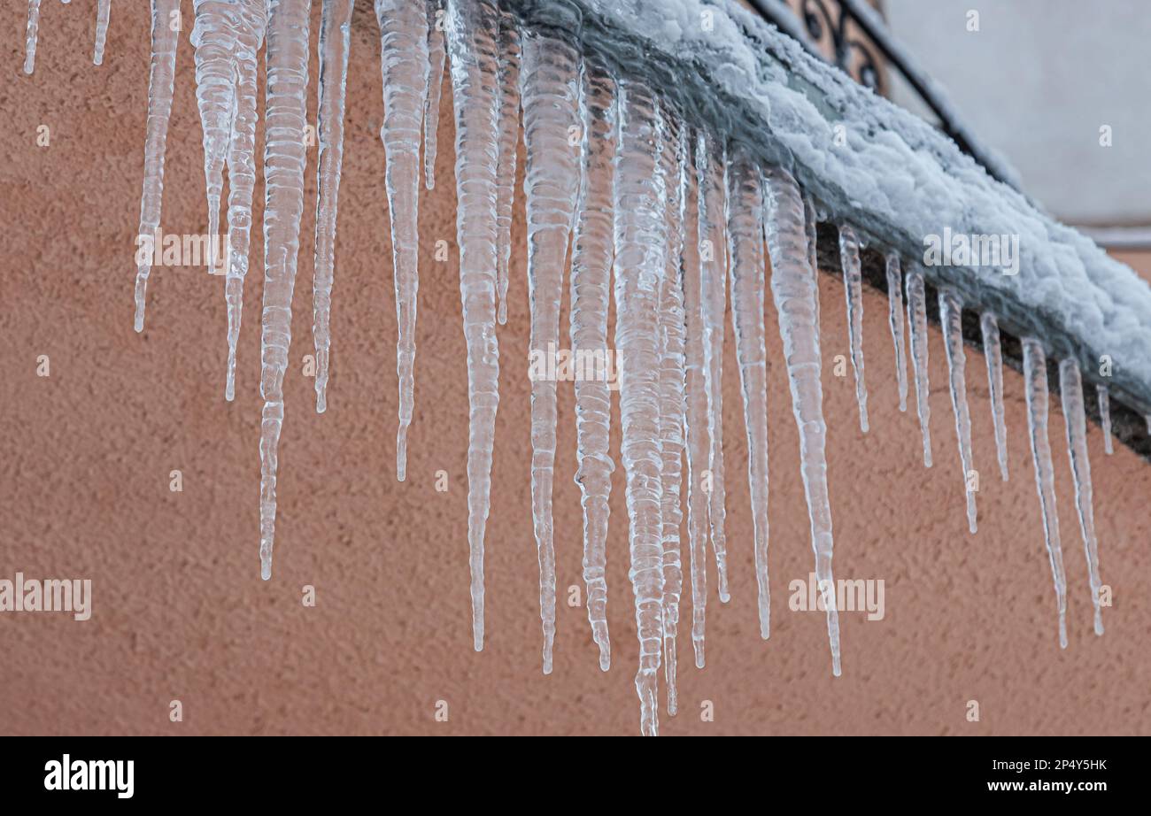 Icicles on the roof. The drain is full of snow and ice. Icicles falling ...