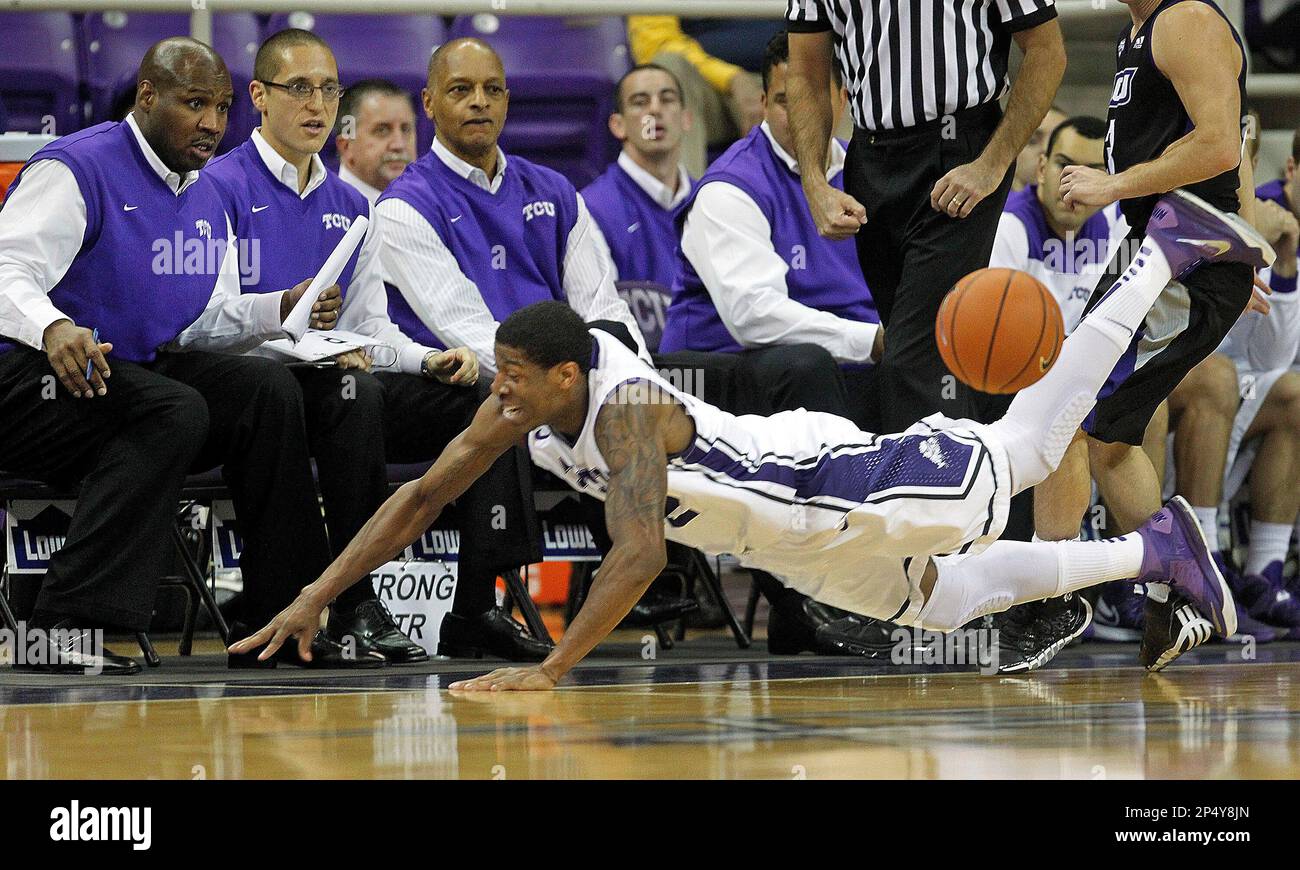 TCU's Jarvis Ray dives for a loose ball as coaches look on during an ...