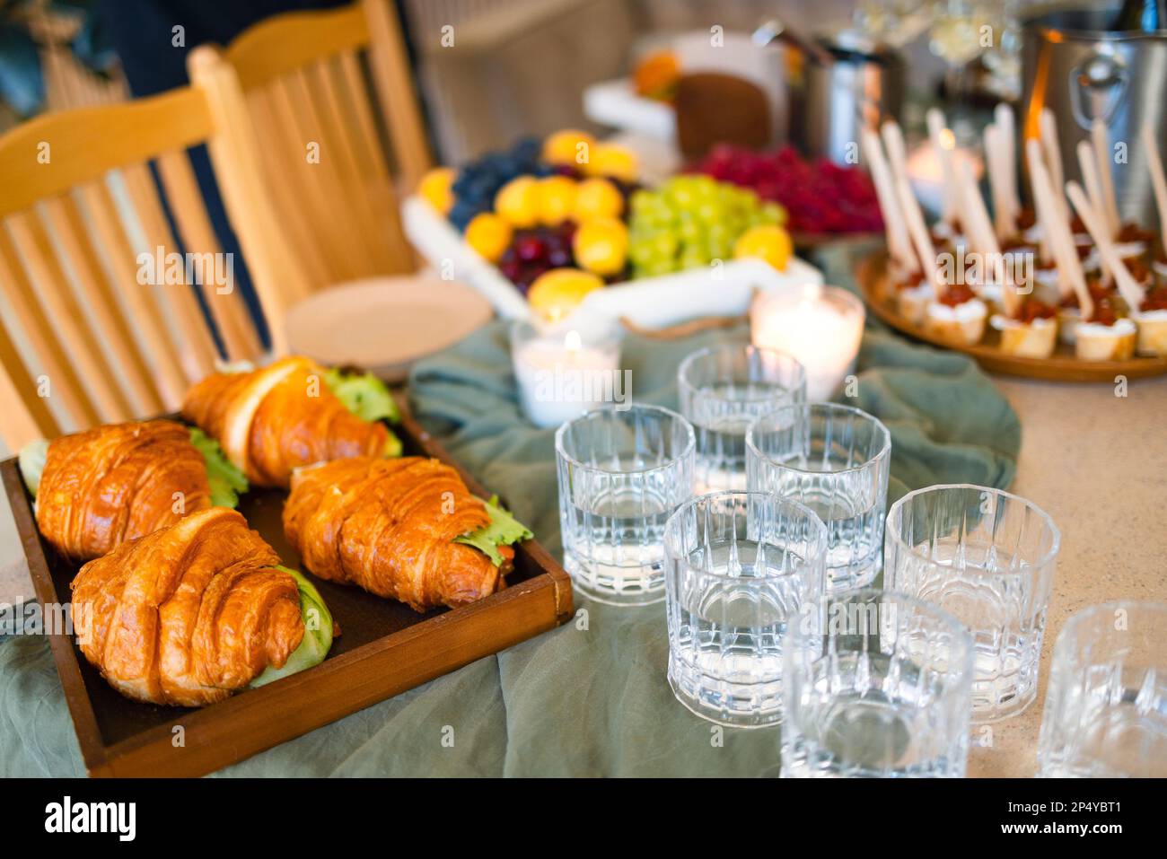 Swiss table at the party. Close up of croissants with greens and ...
