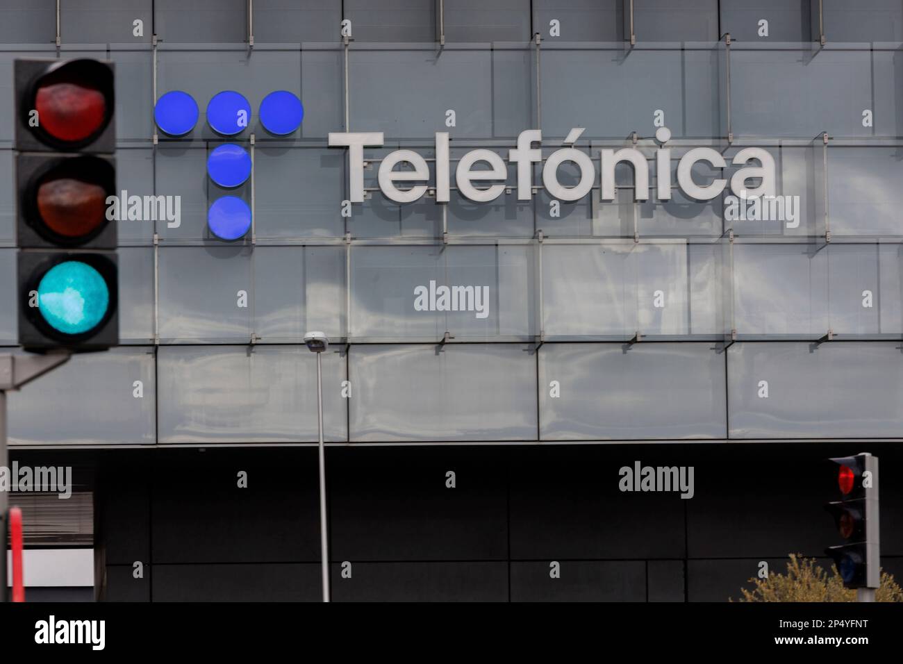 A green traffic light in front of the façade of Telefónica's ...