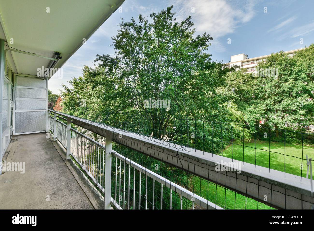 a balcony with trees and buildings in the background, taken from an ...
