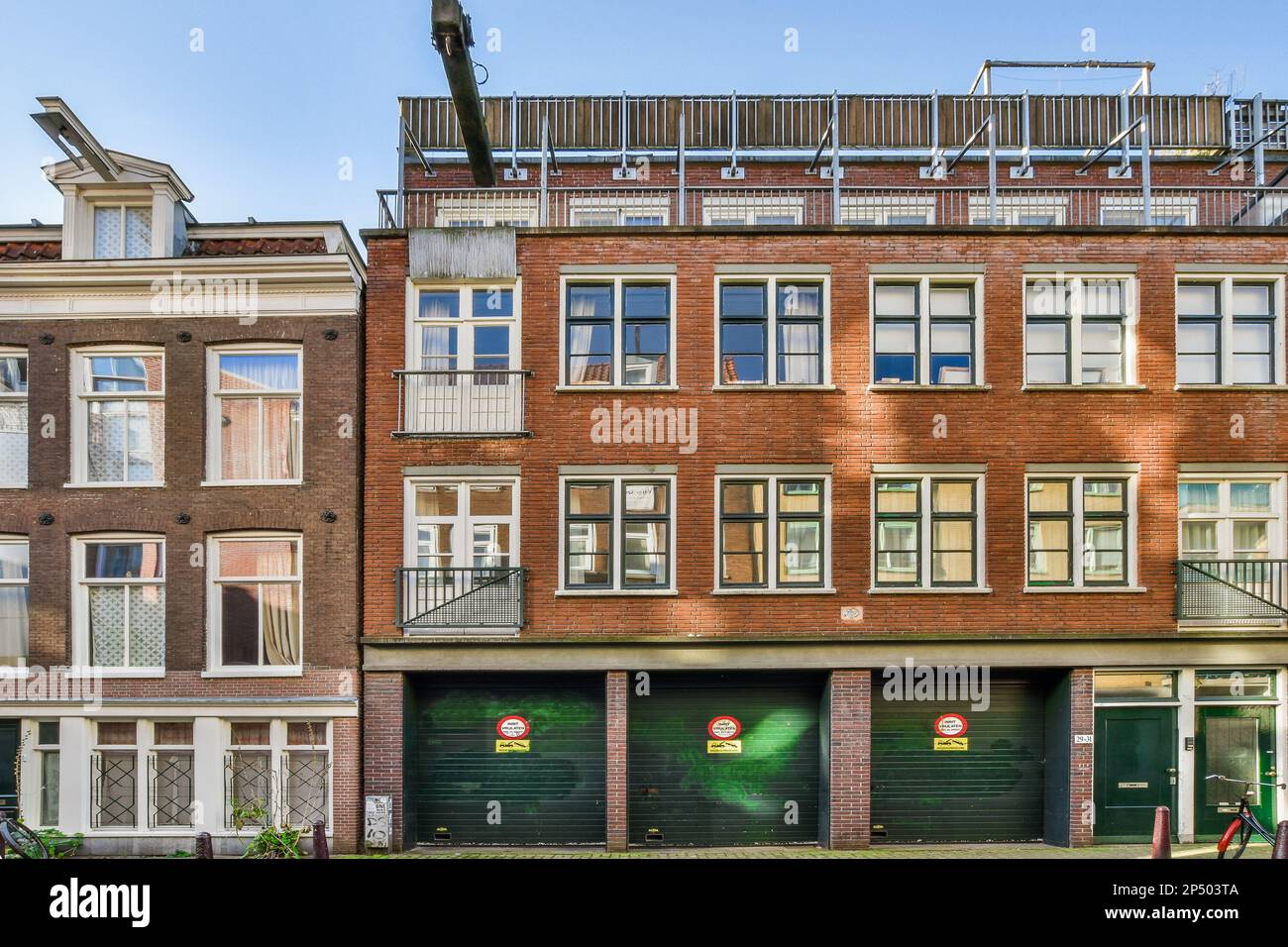 an apartment building in the middle of a street with cars parked on ...