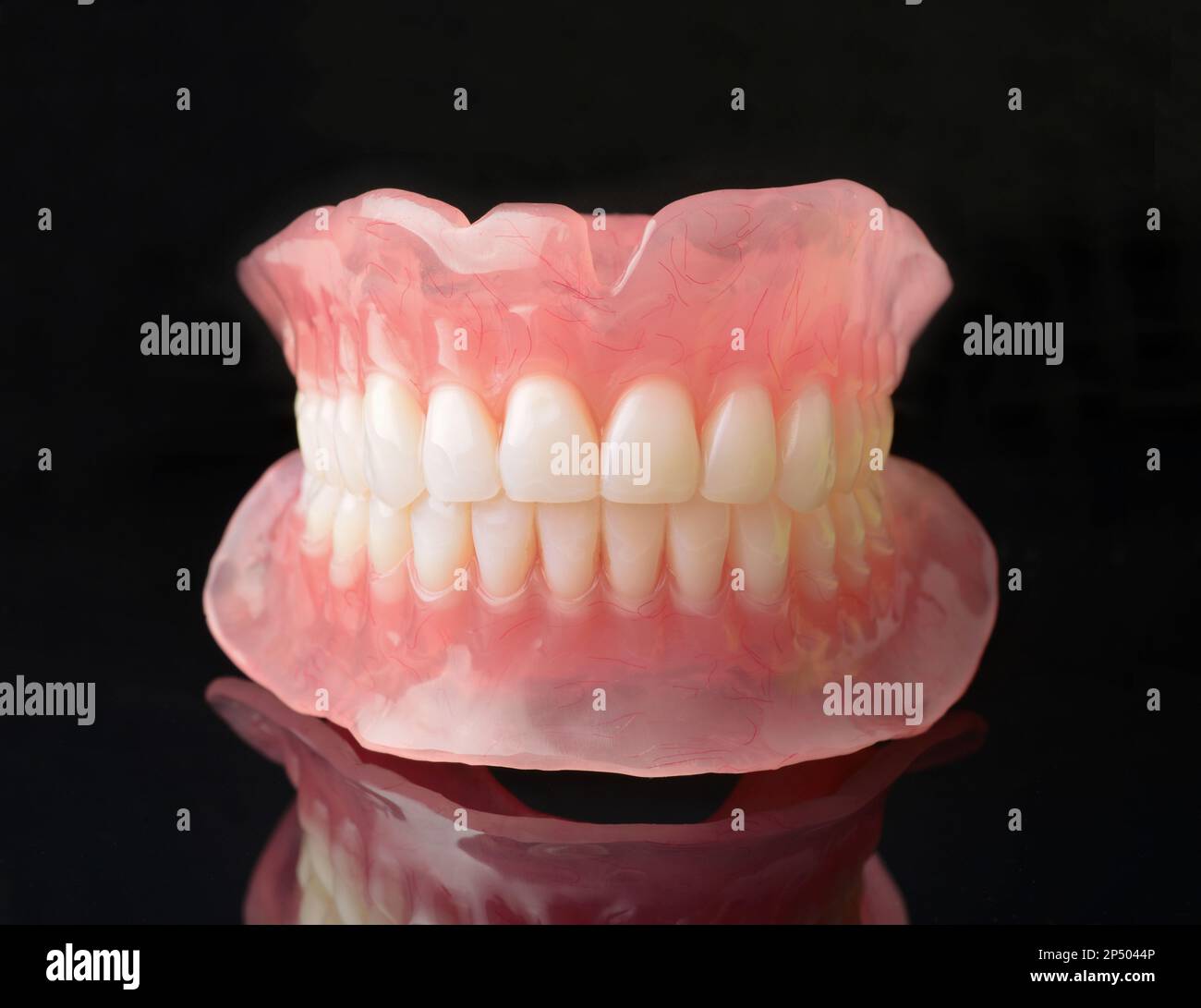 Dental full denture on black background Stock Photo - Alamy