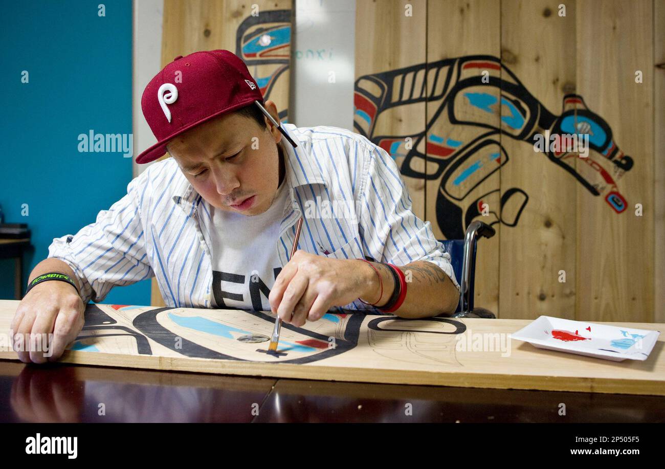 Artist Delfine Decker paints cedar planks to form a wolverine screen at ...