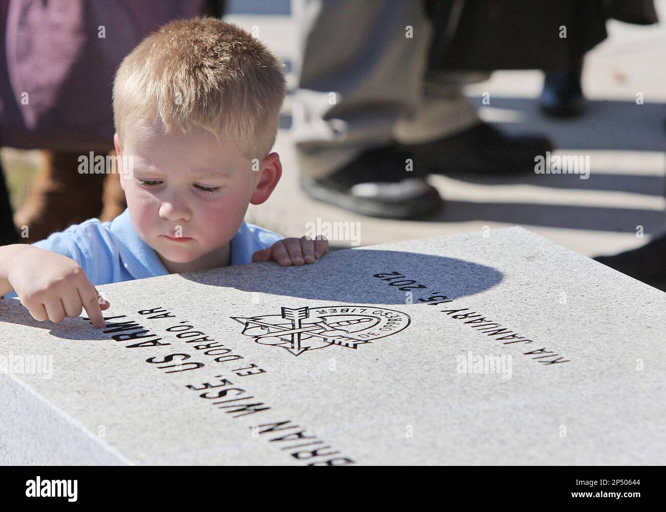 Luke Wise traces out the lettering on a memorial bench that was ...