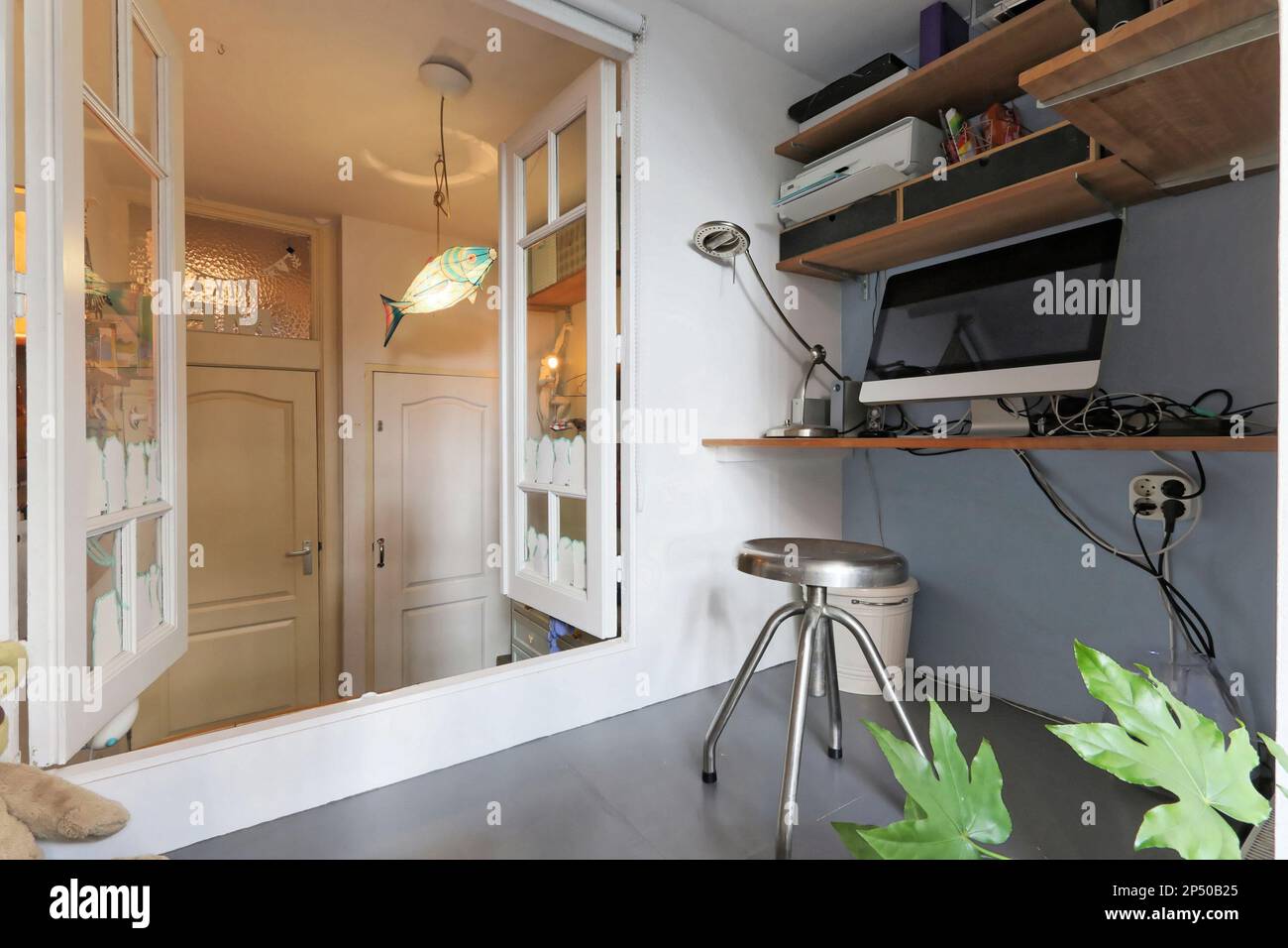 a small room with a desk, chair and computer monitor on the wall next ...