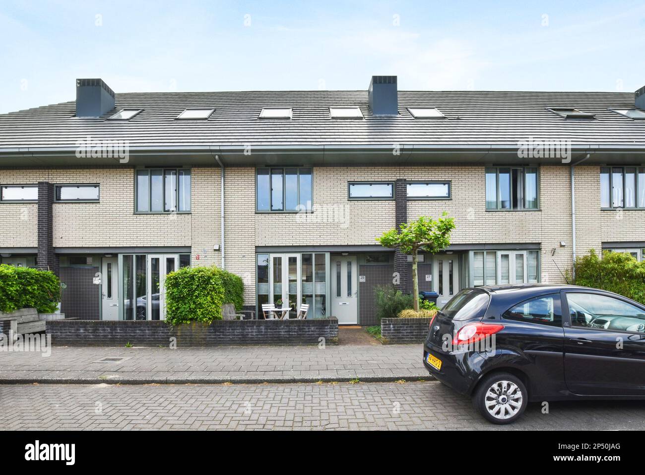 an apartment building with a car parked in the driveway and two cars ...
