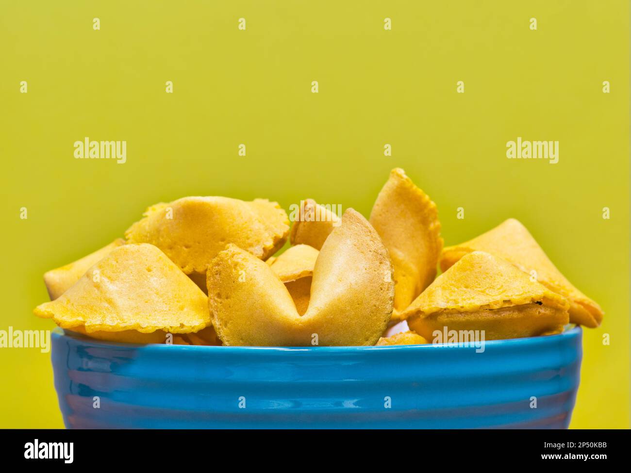 Unopened fortune cookies in a blue ceramic bowl partial, isolated on a ...