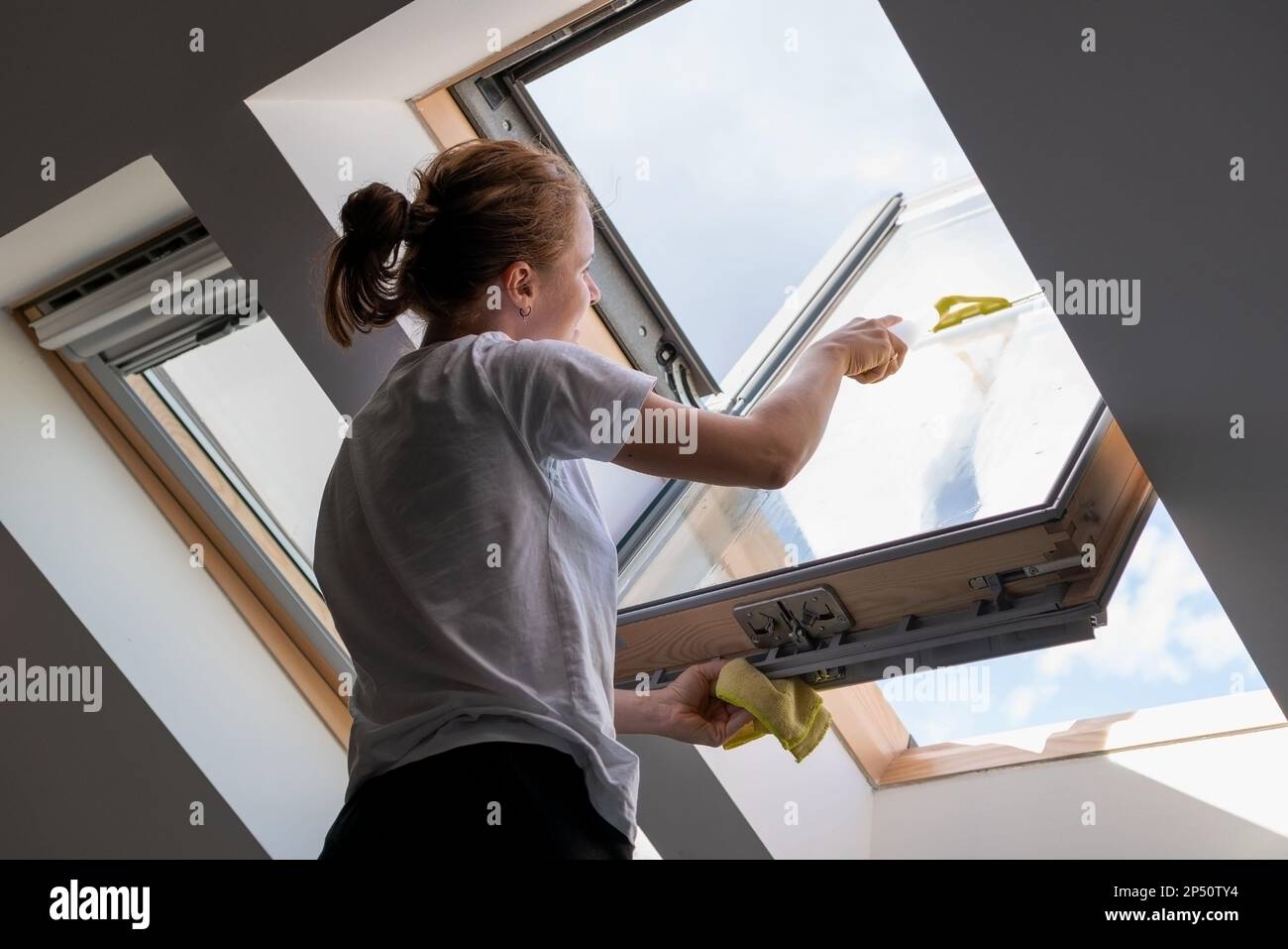 Woman cleaning window skylights at home Stock Photo - Alamy