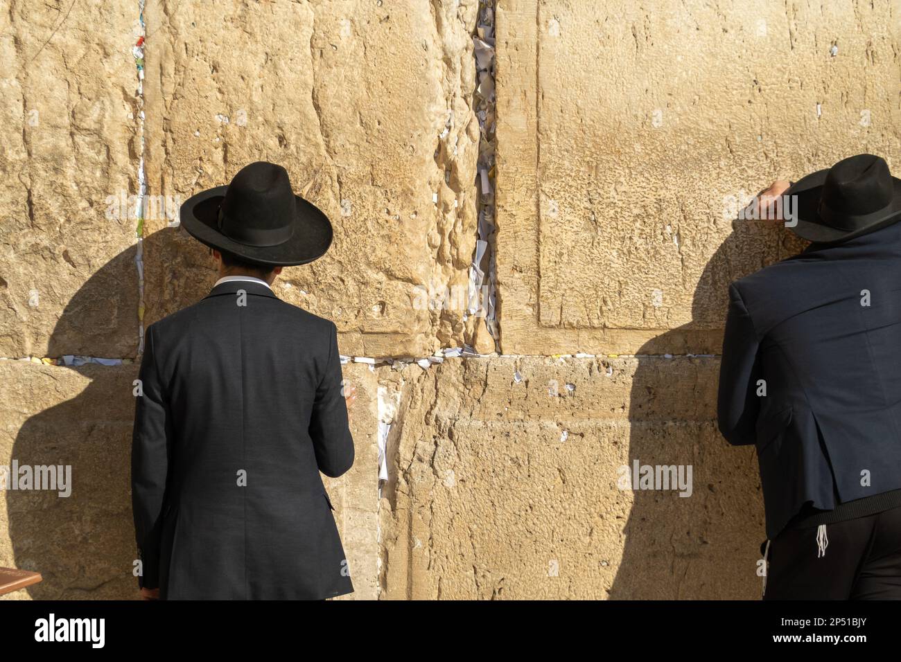 Men facing holy stone wall while praying Stock Photo - Alamy