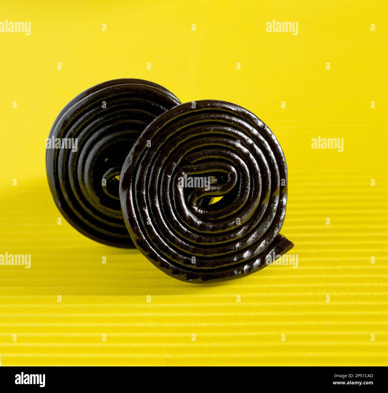 gummy licorice wheel on yellow background Stock Photo - Alamy