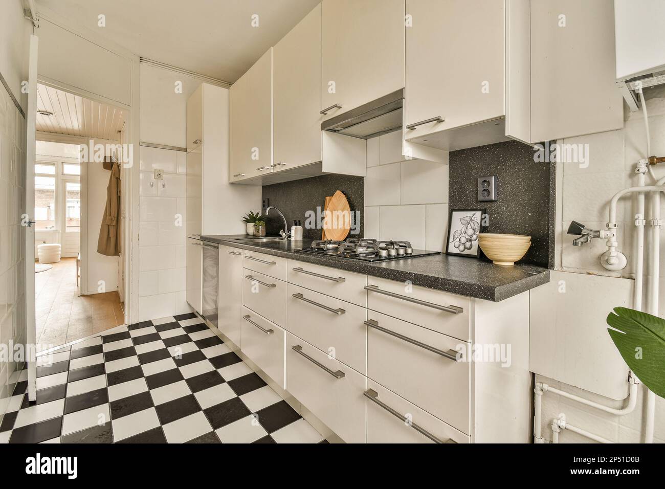 a kitchen with black and white checkered tiles on the floor in front of ...