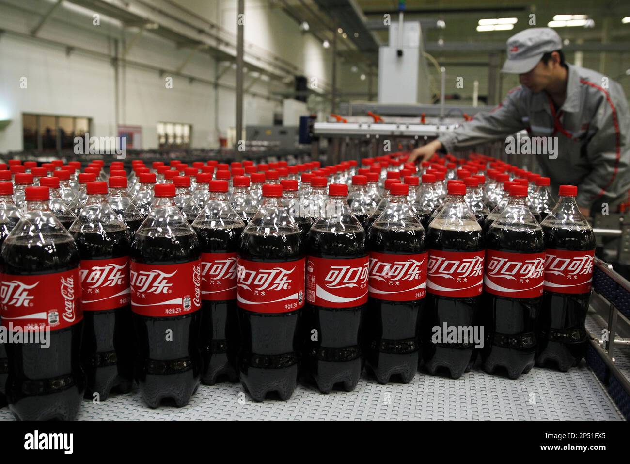An employee works on a production line at the Coca-Cola company's new ...