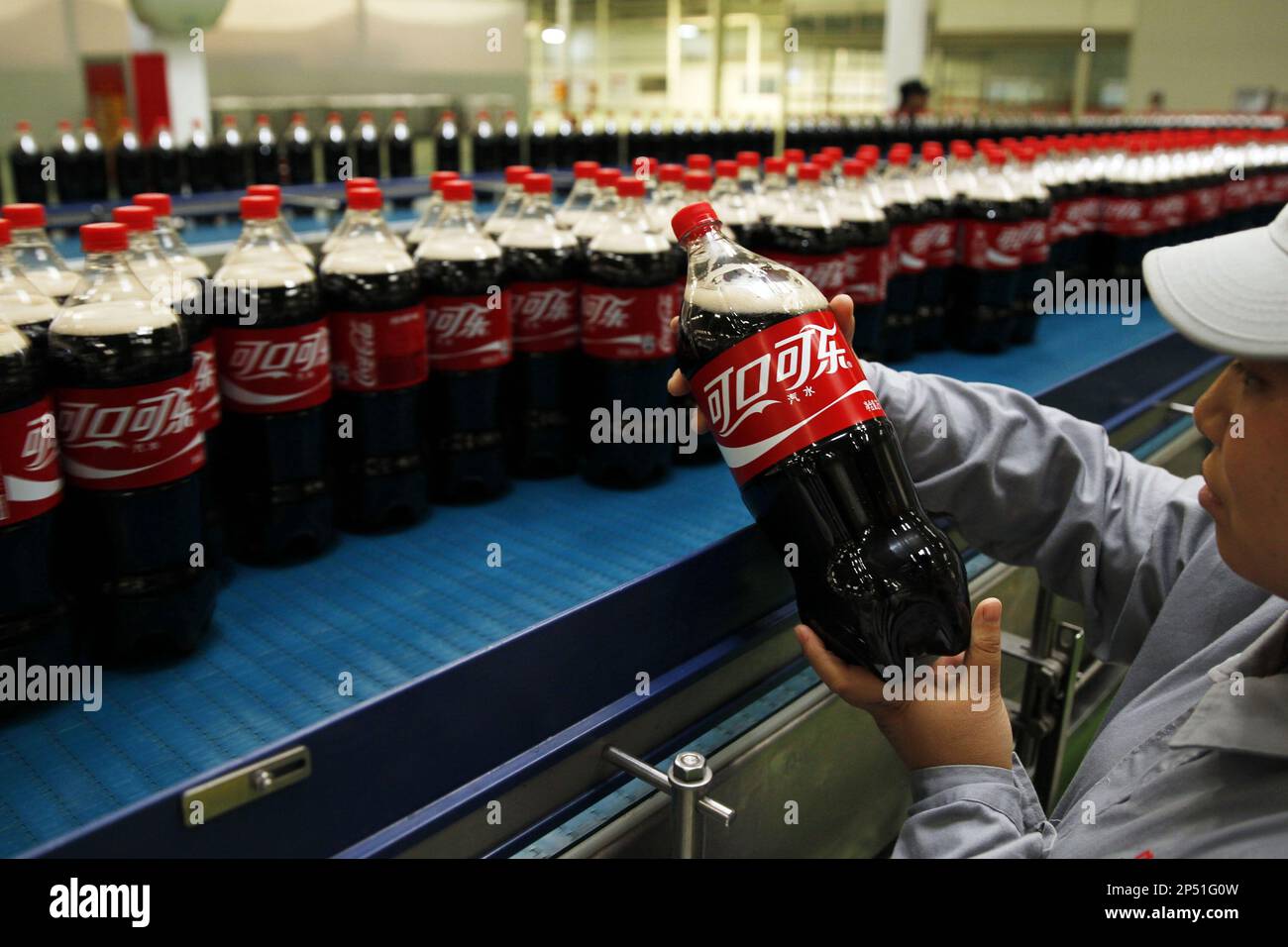 An employee works on a production line at the Coca-Cola company's new ...