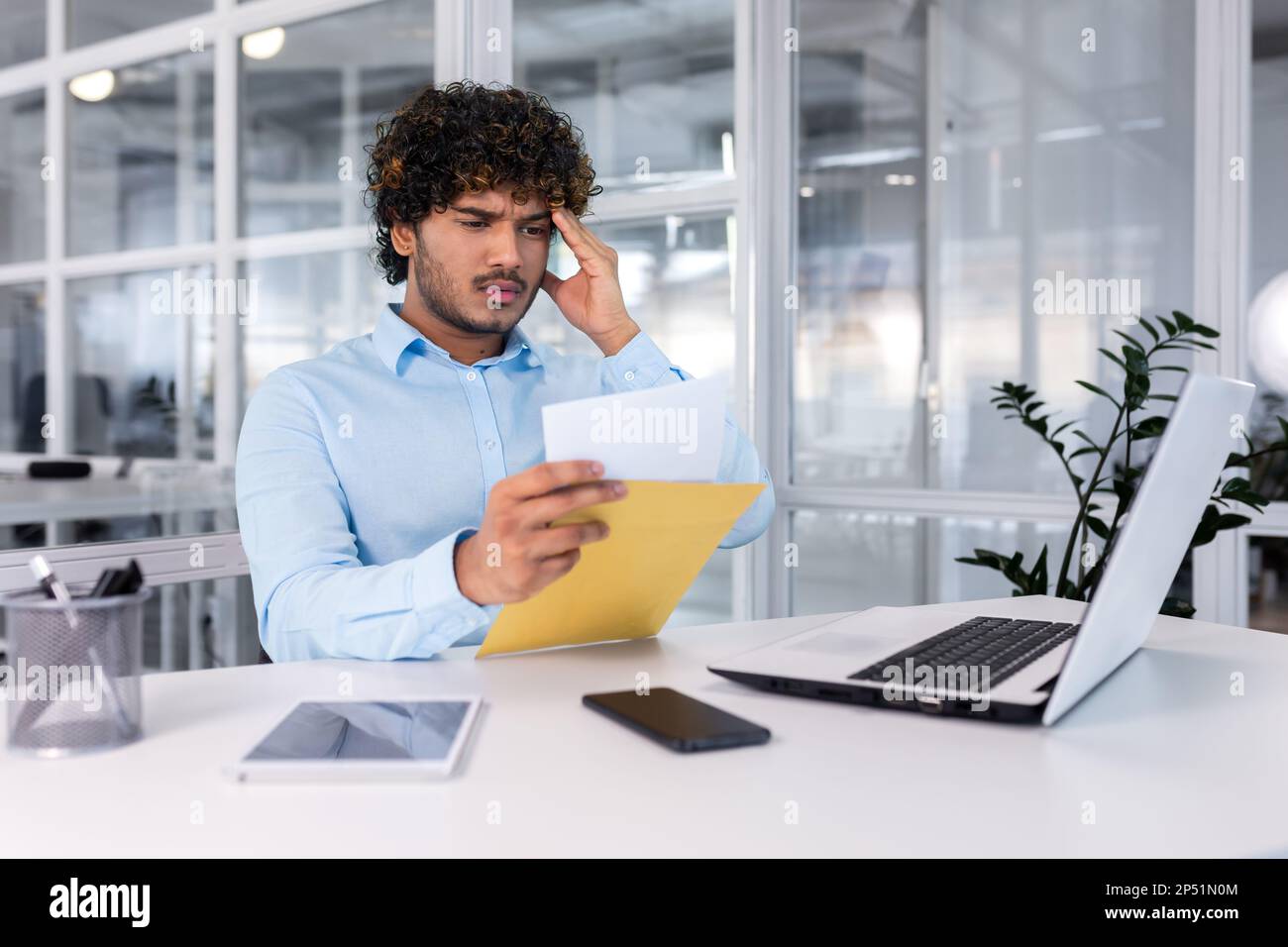 Young businessman at work inside office received mail envelope ...