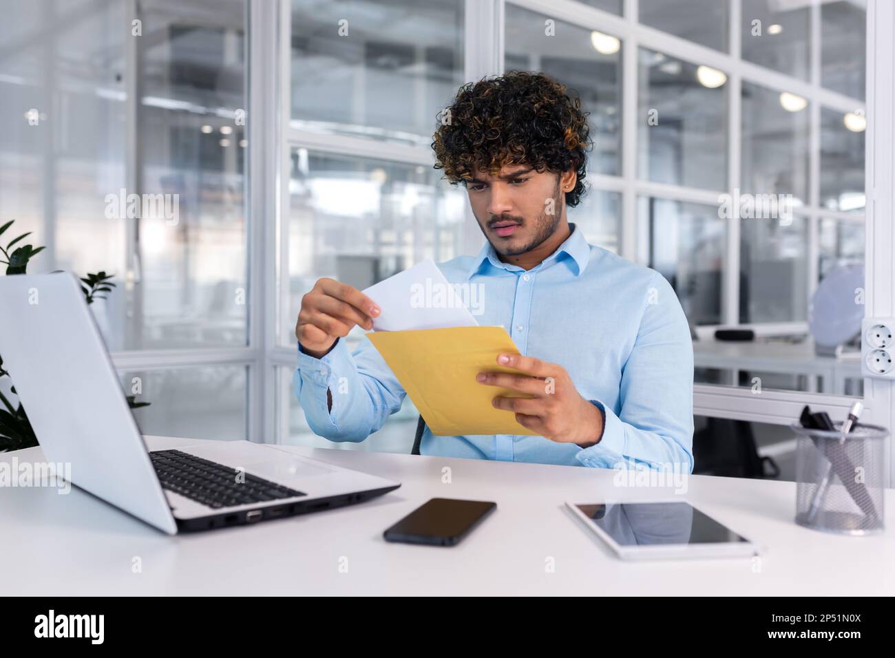 Young businessman at work inside office received mail envelope ...