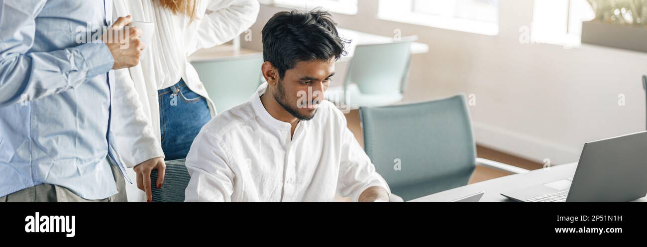 Group of young diverse coworkers analyzing sales report while working ...