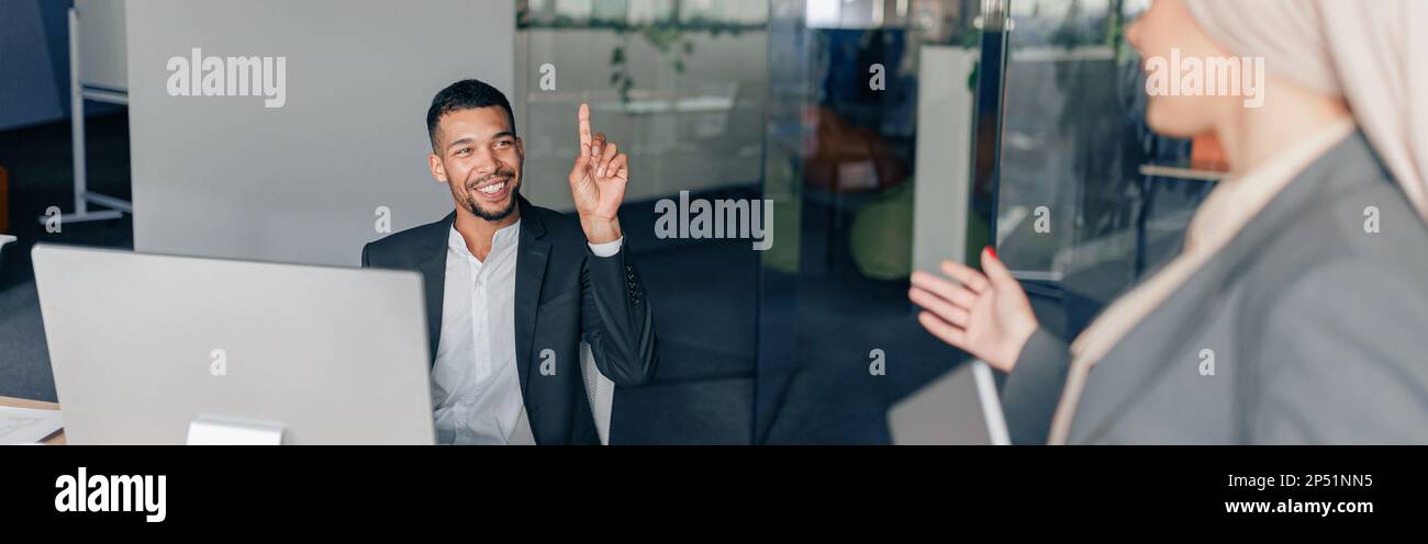 Two multiracial coworkers talking during working day in office Stock ...