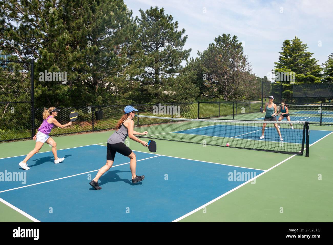 Two players approach the net in a comptetivie doubles game of ...