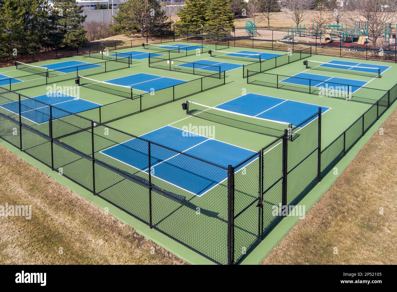 Aerial view of a pickleball complex with blue and green courts beside a ...