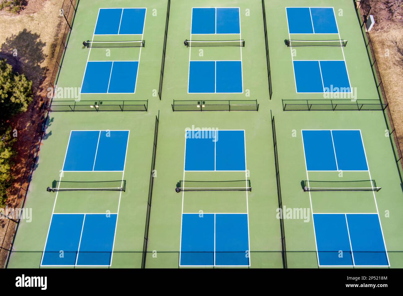 Aerial view of a pickleball complex with blue and green courts beside a ...