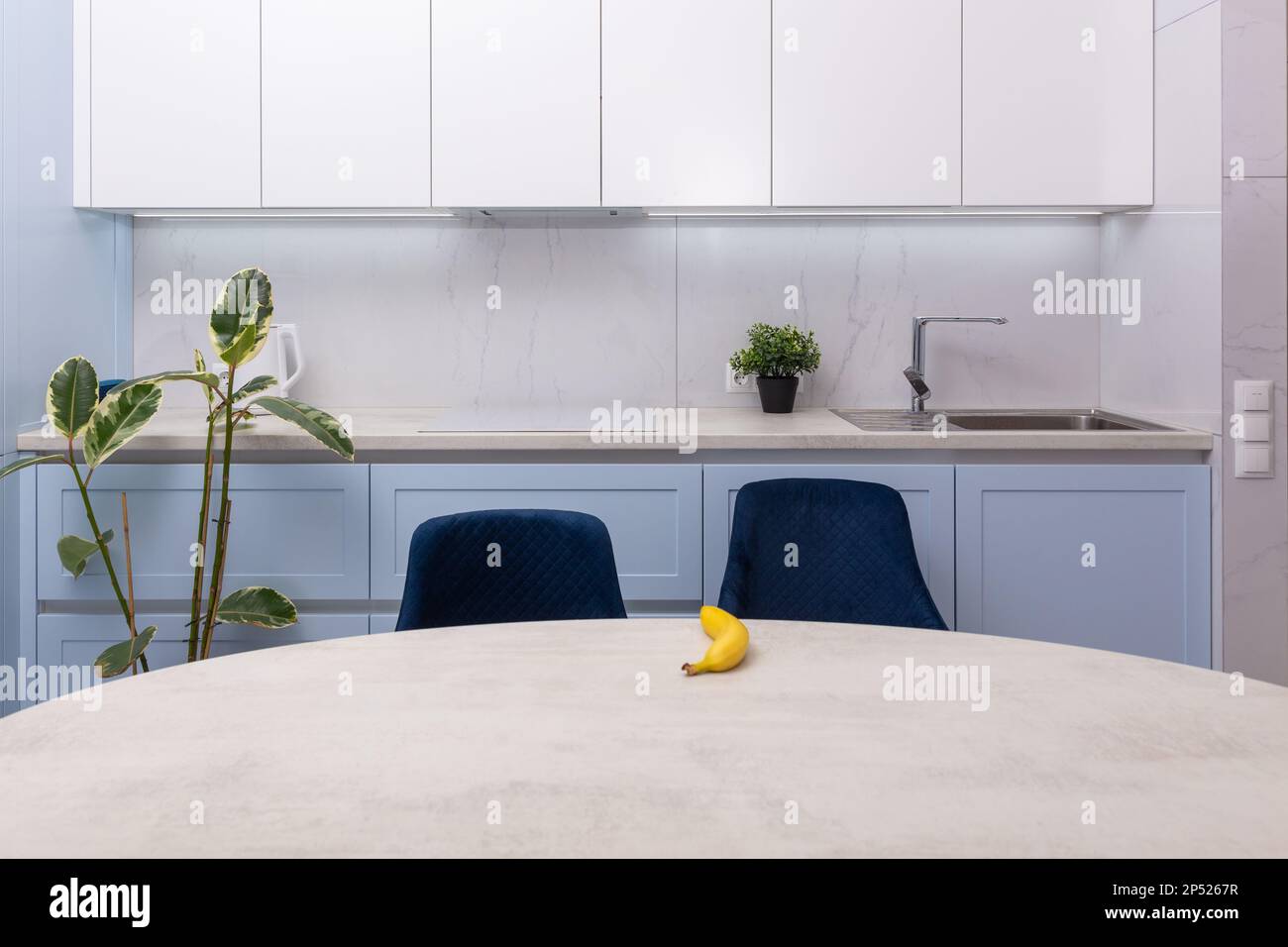 Dining table in interior of modern kitchen. Round kitchen table and two ...