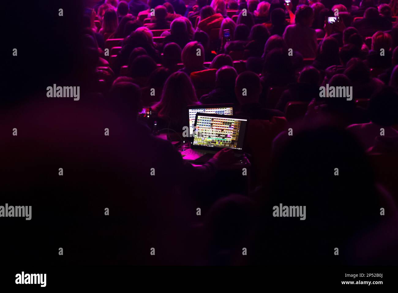 Auditorium seat in the theather. Soundman on the mixing console during ...