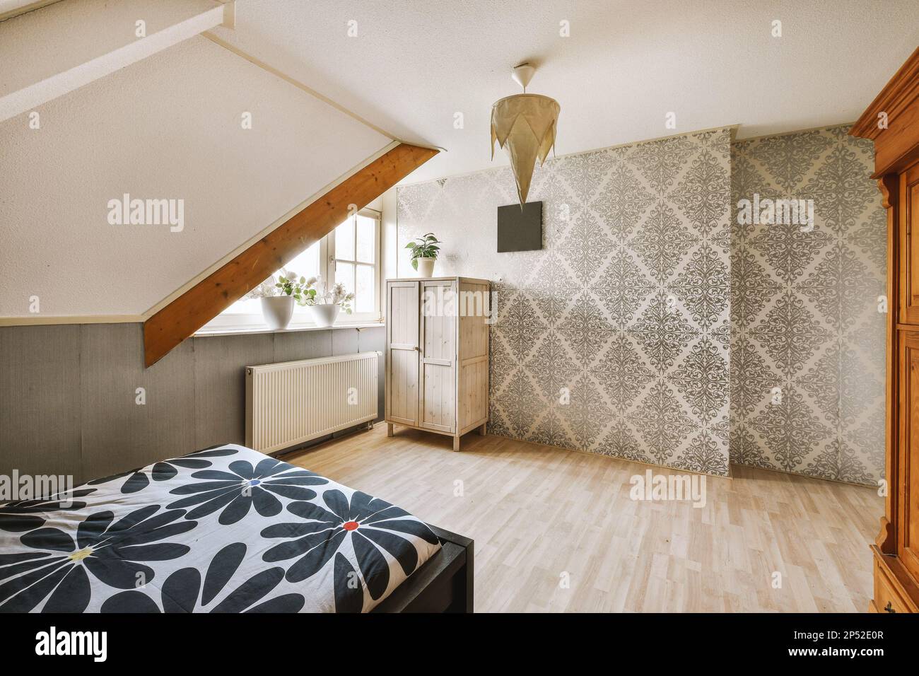 a bedroom with wood flooring and wallpaper on the walls in an attic ...