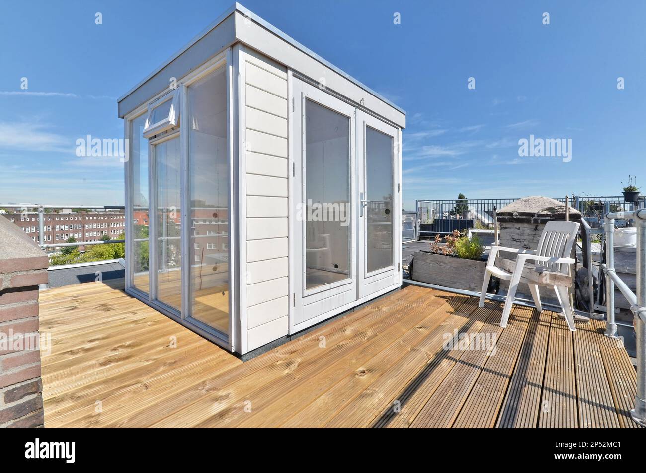 a small house on the roof with wooden flooring and white sidings ...