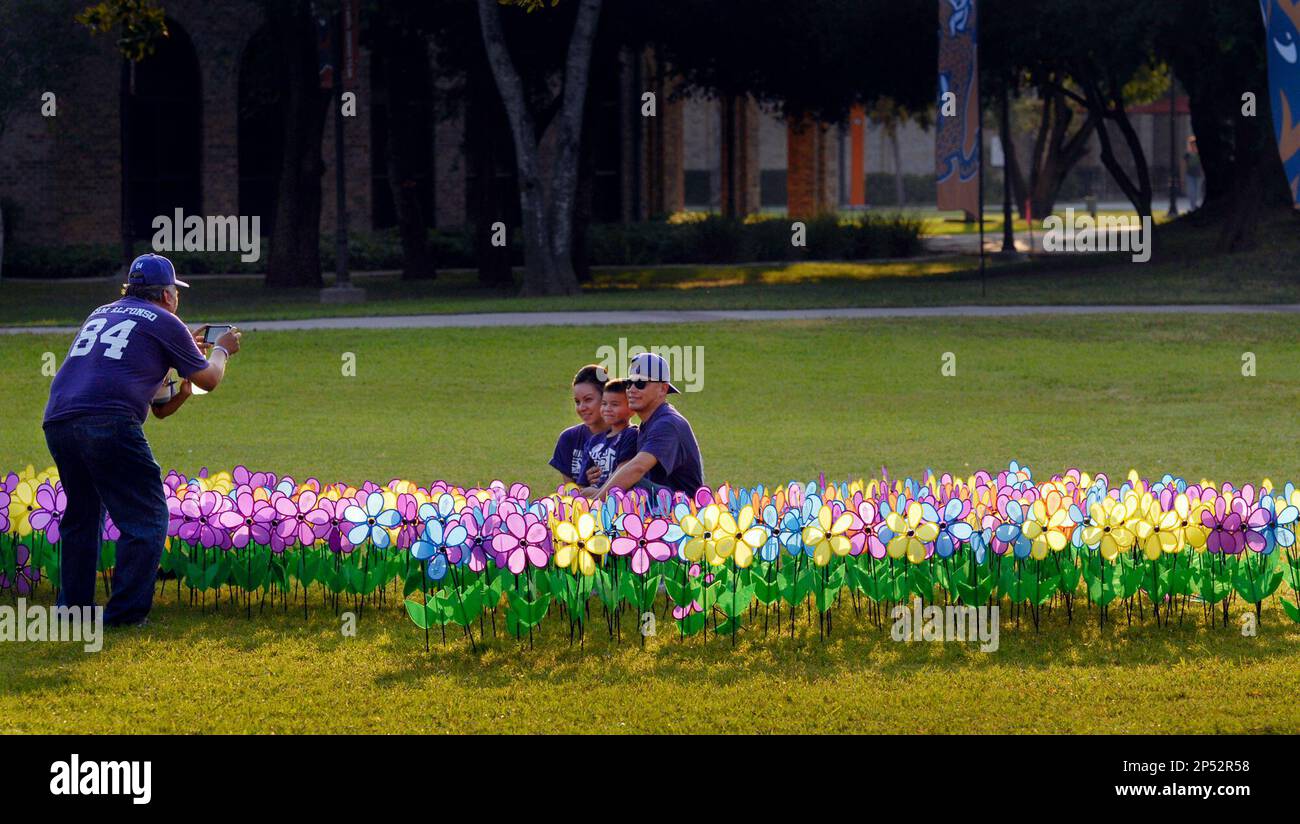A family poses for a photo with pin wheels before the annual Walk to ...