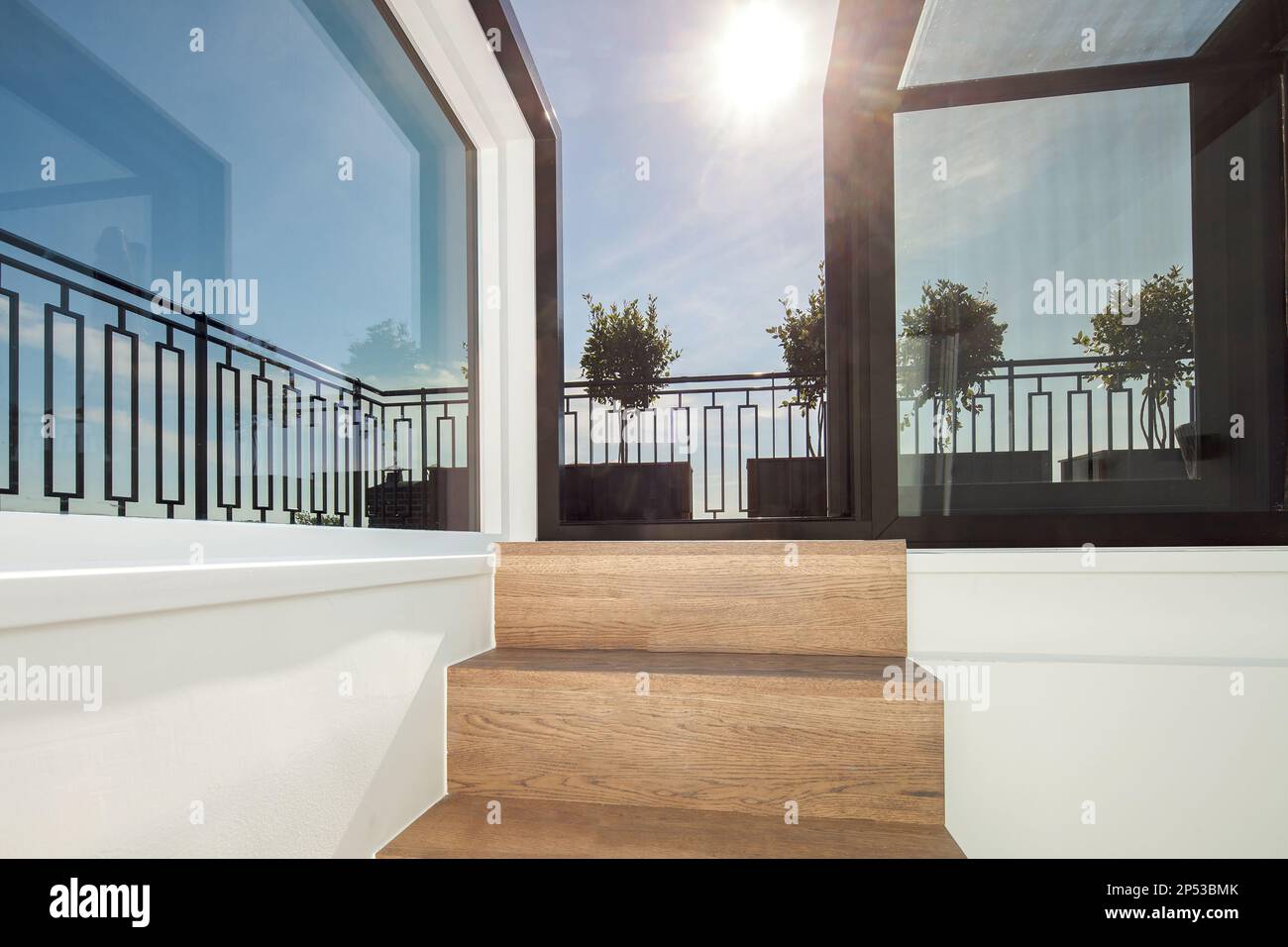 an outside area with stairs and railings in the fore - lit sun shining ...