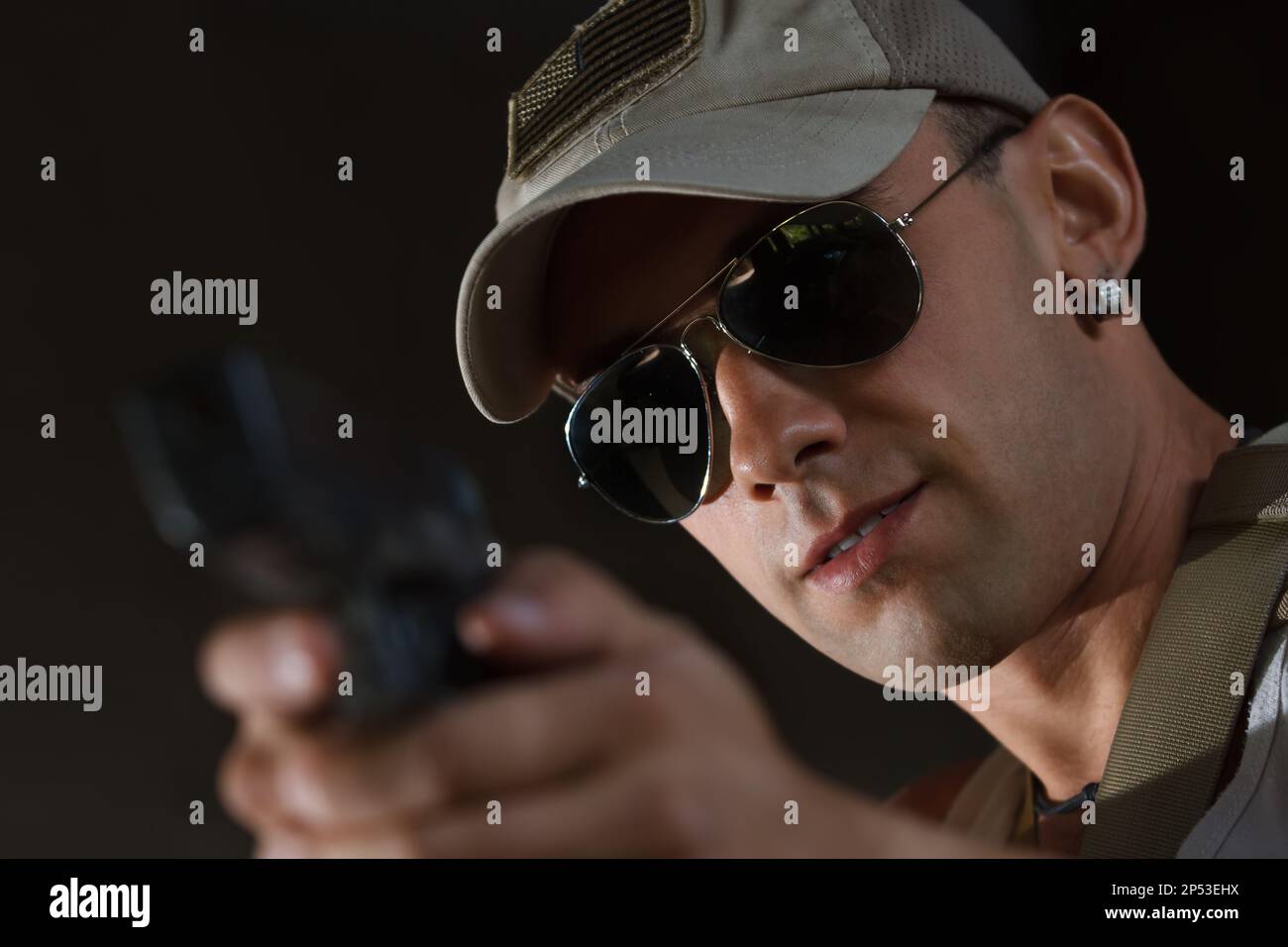 Cool young Ukrainain soldier aiming the target with a pistol. Portrait ...