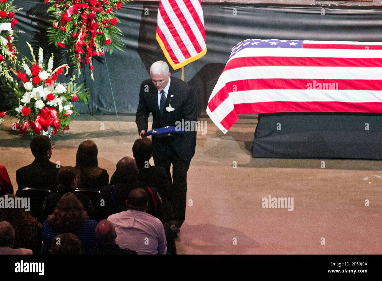 Indiana Gov. Mike Pence hands an Indiana state flag to the widow of ...