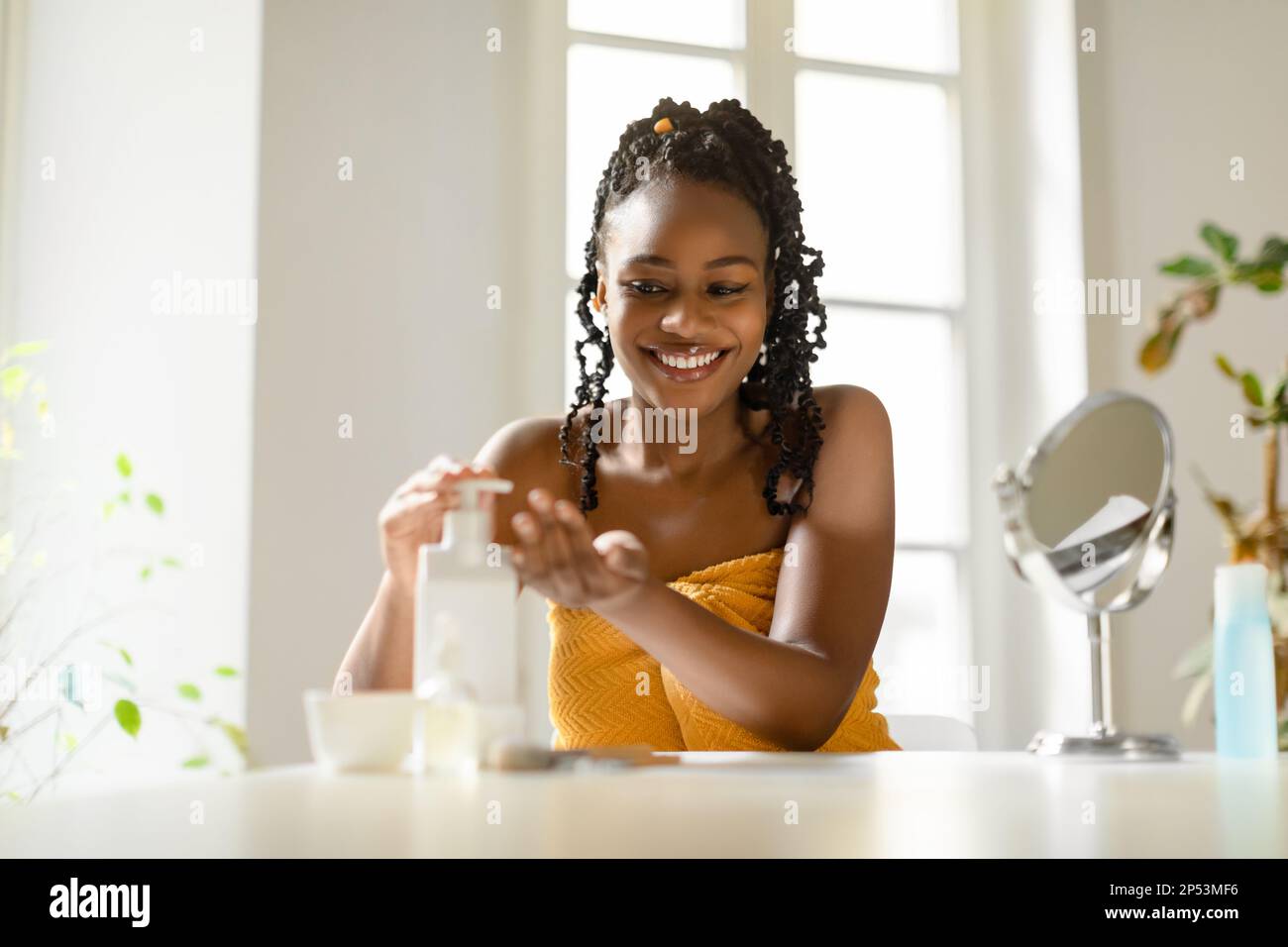 Happy african american woman pouring moisturising body lotion from ...