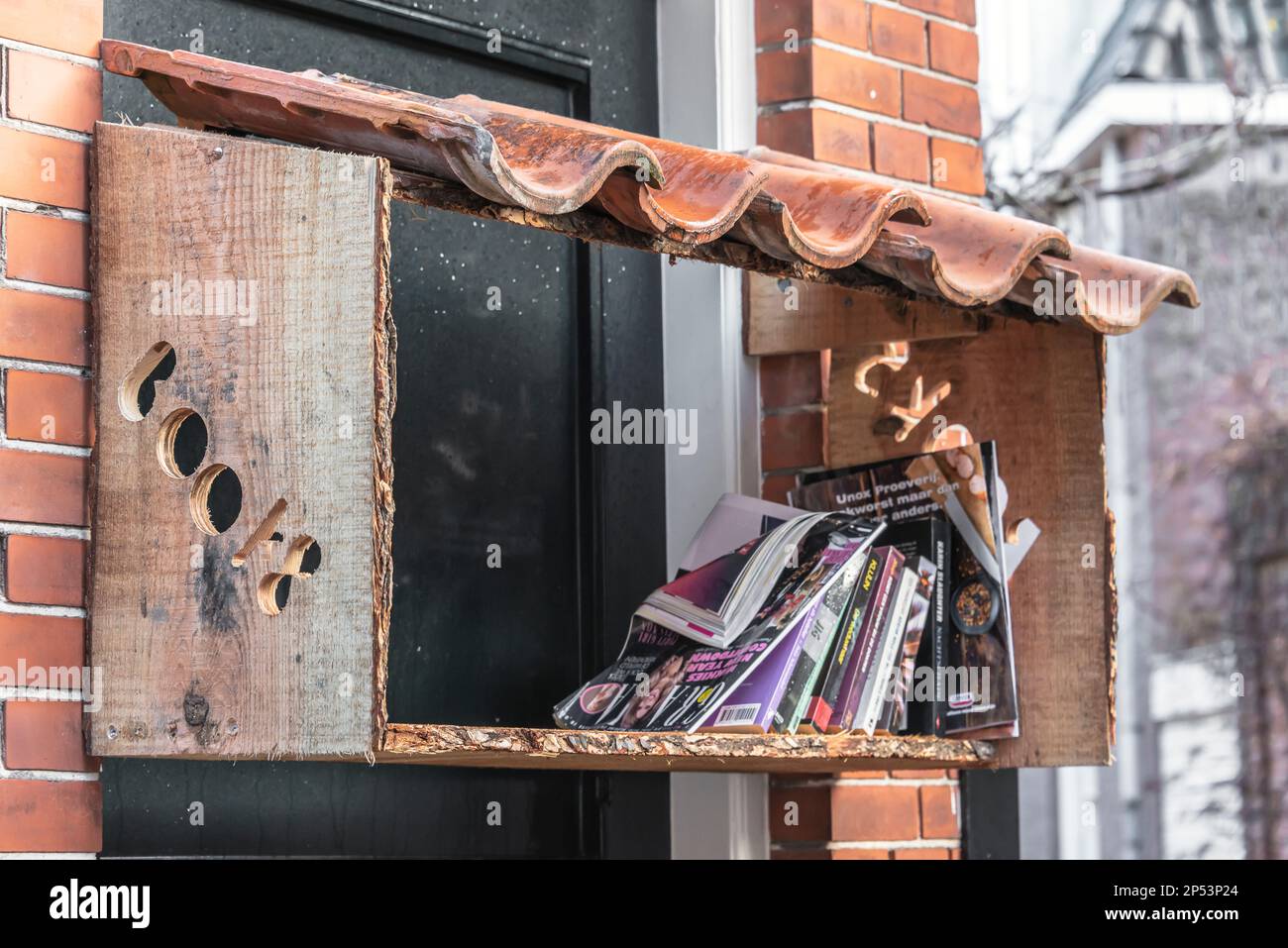 Bookshelf made of wood filled with books and magazines with roof tiles ...