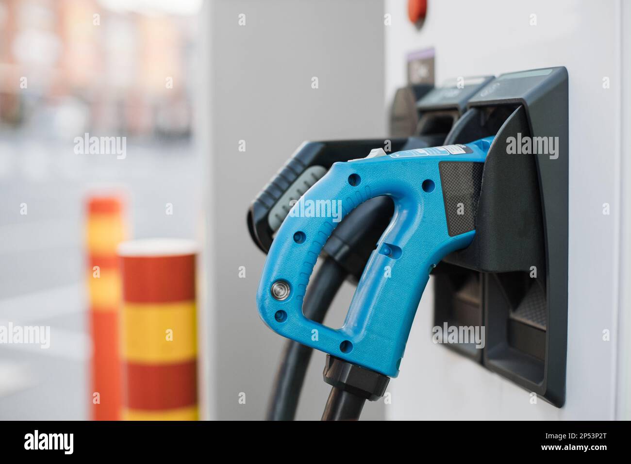 Electric charging station with blue and black power cords. Blurred ...