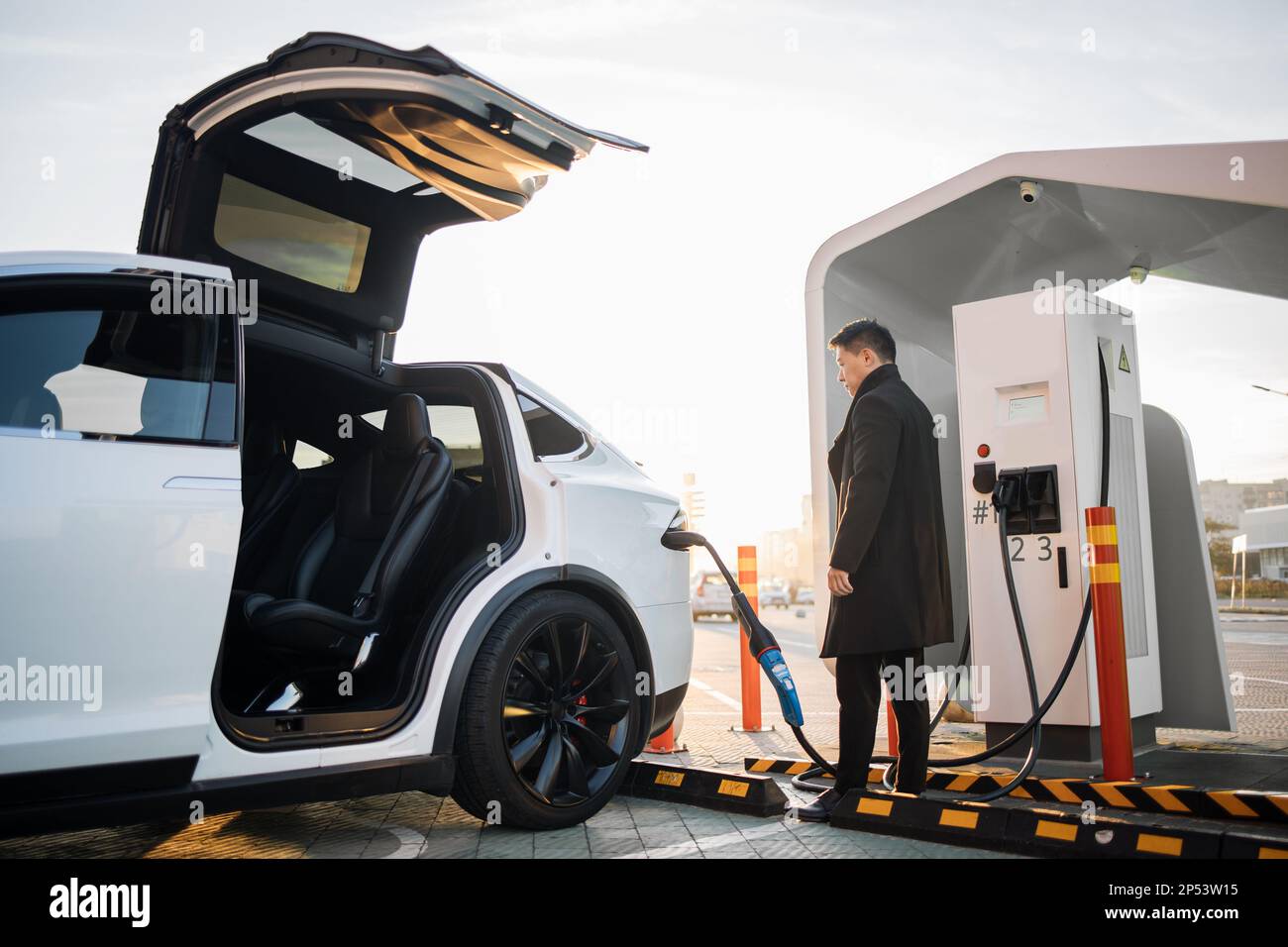 Side view of confident asian man in stylish formal wear standing near ...