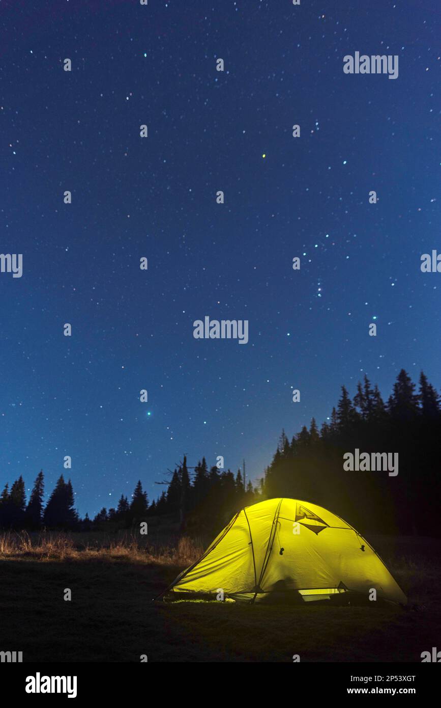 Luminous tourist tent under the starry sky. Tourist tent at night in ...