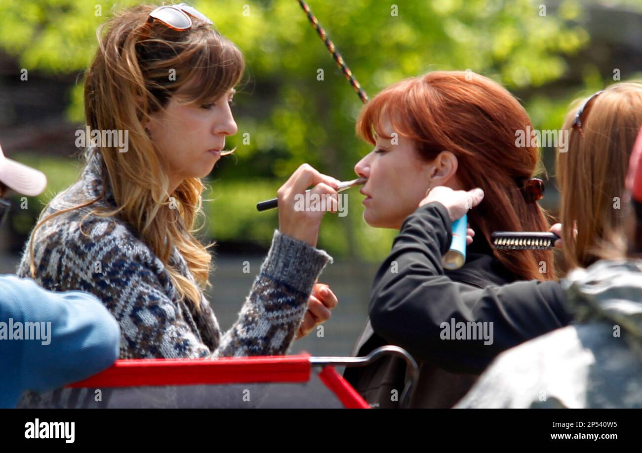 A makeup artist touches up Lauren Holly's makeup between scenes on the ...