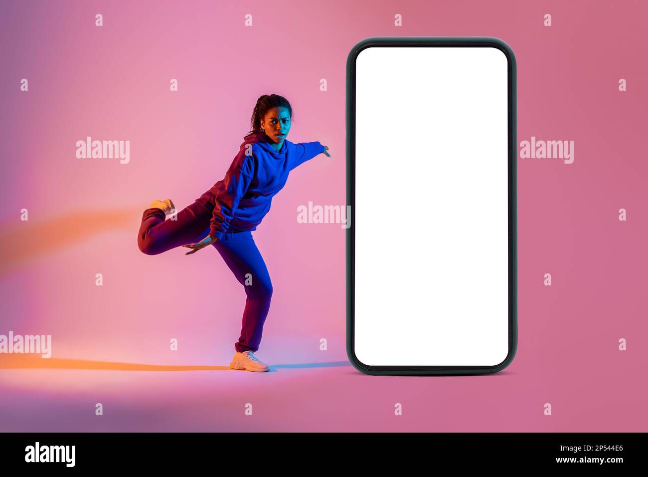 Professional dancer jumping near huge smartphone with white blank ...