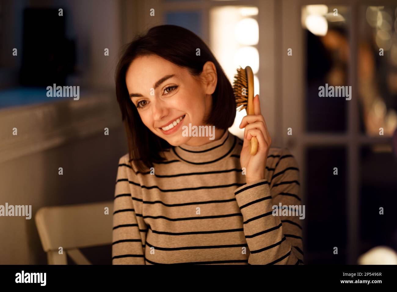 Beautiful woman combing her short hair with brush at home Stock Photo ...