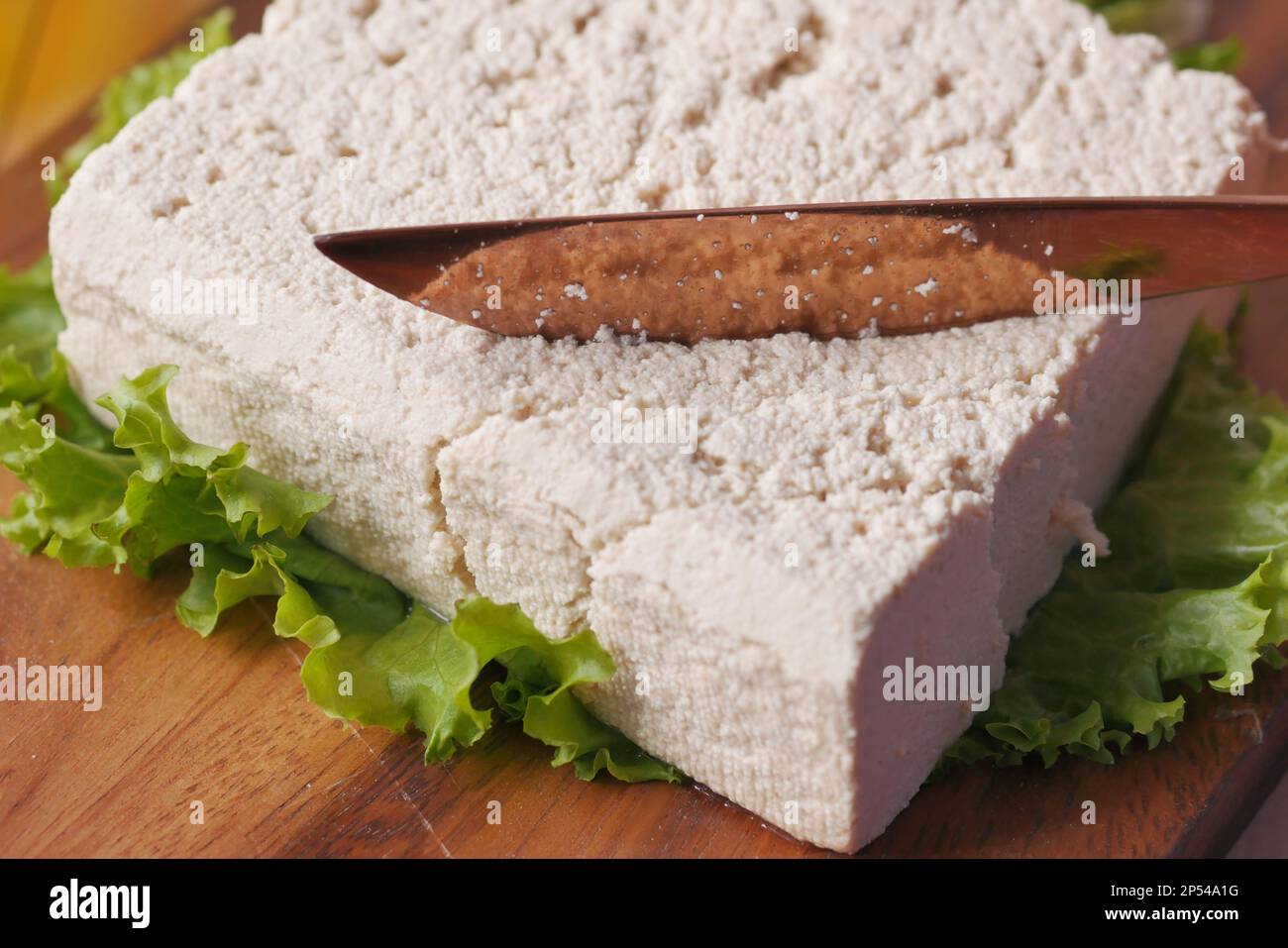 cutting Tofu with knife on a chopping board Stock Photo - Alamy