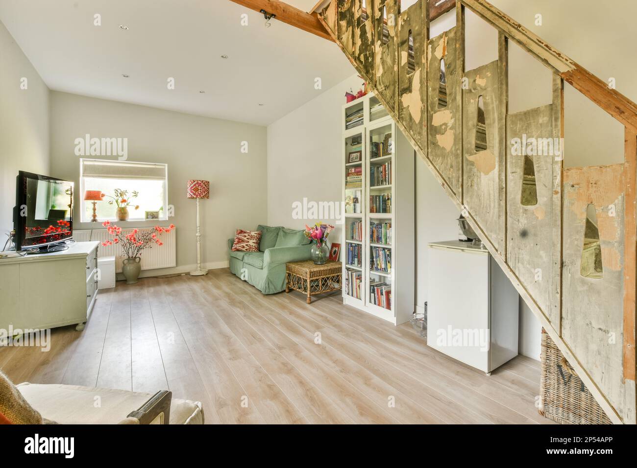 a living room with wood flooring and white walls, including a wooden ...
