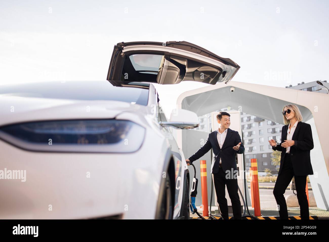 Stylish caucasian woman talking with asian car dealer while buying new ...