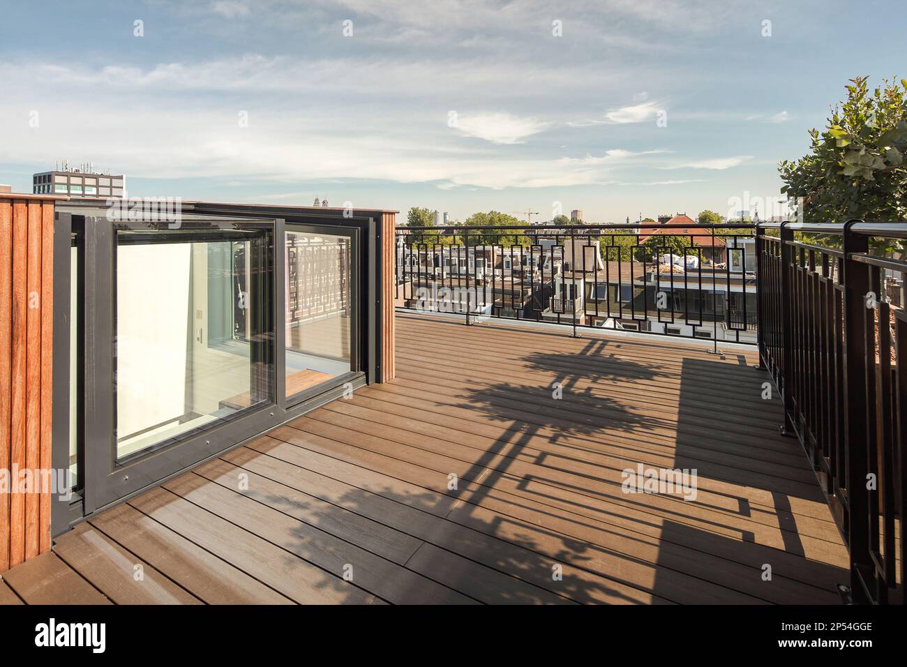 a balcony with wooden decking and glass doors that open to let in the ...