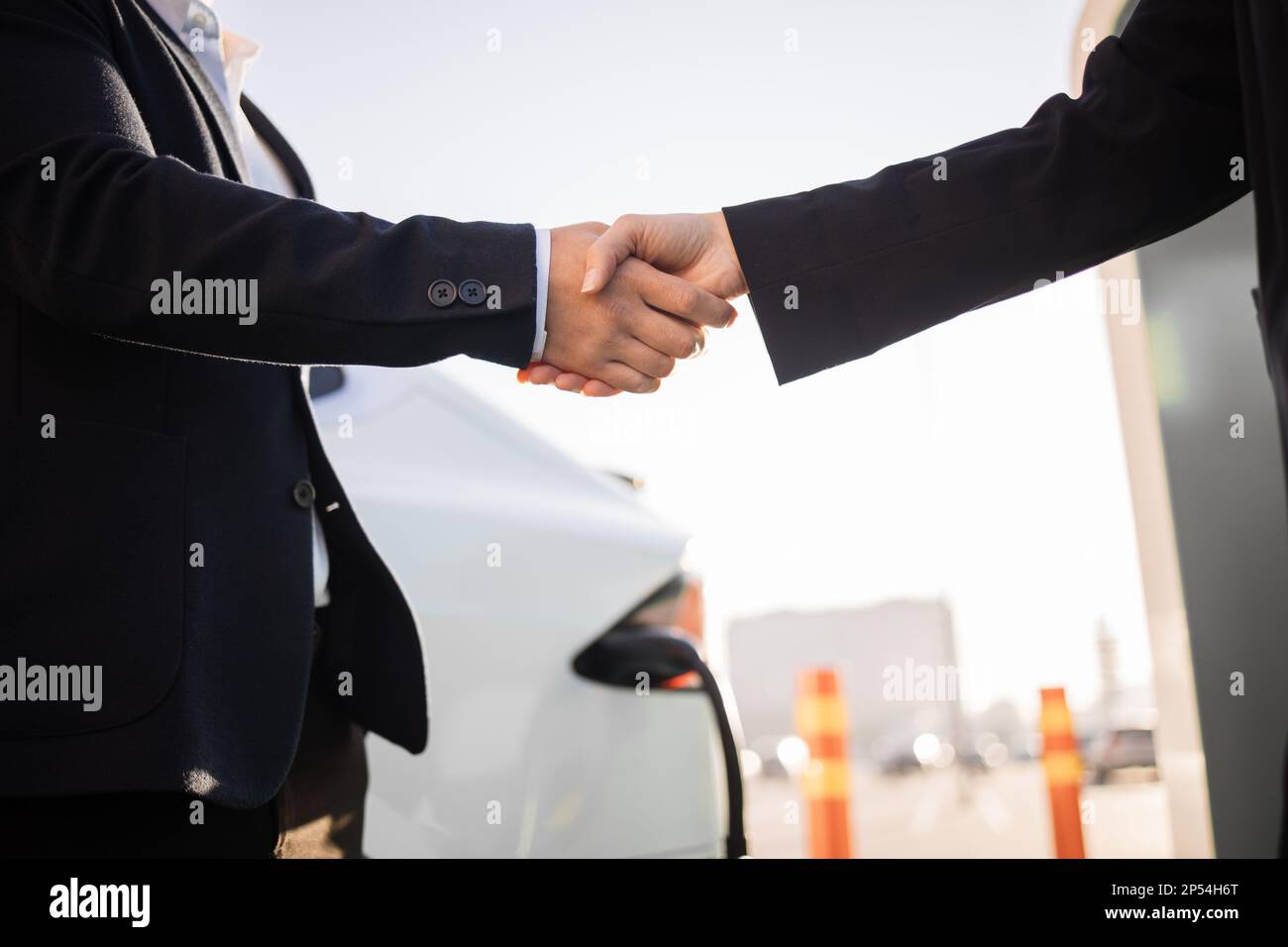 Close up of caucasian woman and asian dealership seller shaking hands ...