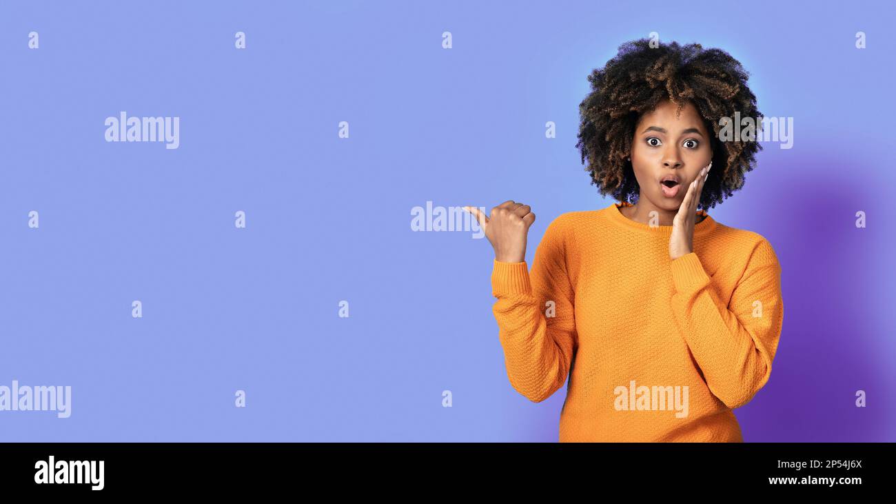 Shocked african american lady pointing at copy space, banner Stock ...