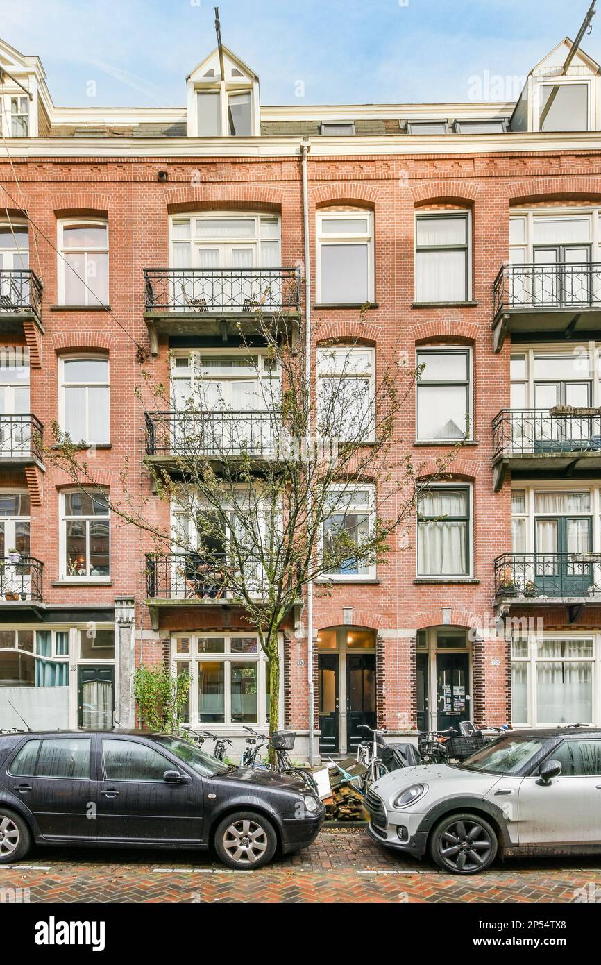 two cars parked in front of a brick apartment building with balks on ...