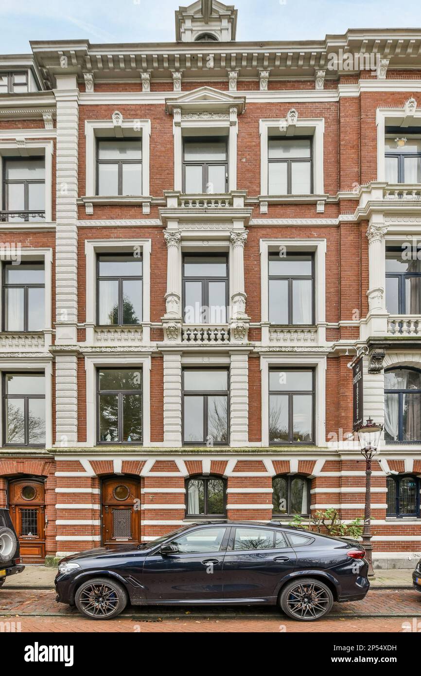 a car parked in front of an apartment building on a street with two ...