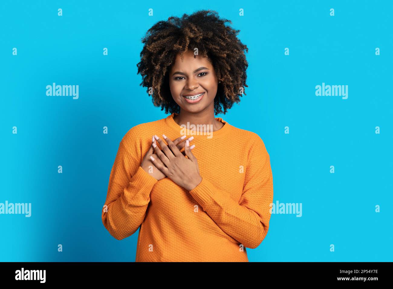 Beautiful african american woman holding hands over chest Stock Photo ...